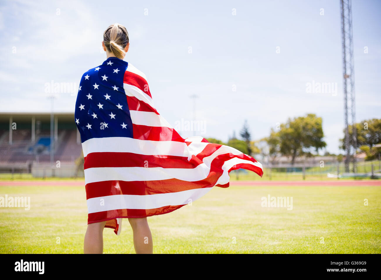 Rear view of female athlete wrapped in american flag Stock Photo - Alamy