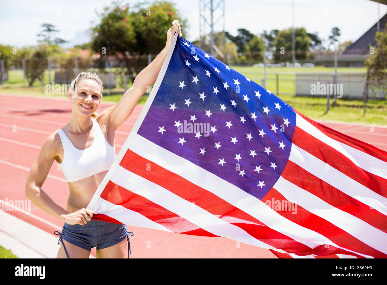 Portrait of happy female athlete holding up american flag Stock Photo ...