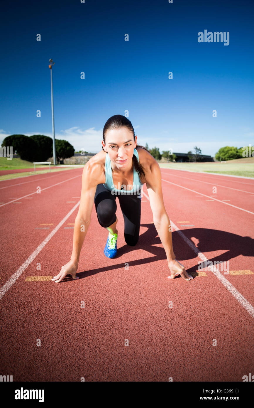 Portrait of female athlete in ready to run position Stock Photo - Alamy