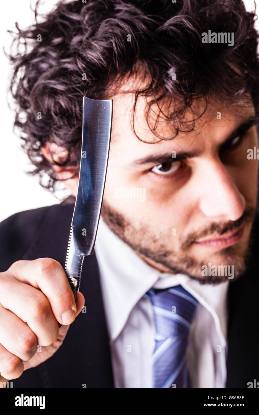 a young and handsome businessman holding a cut-throat razor isolated ...