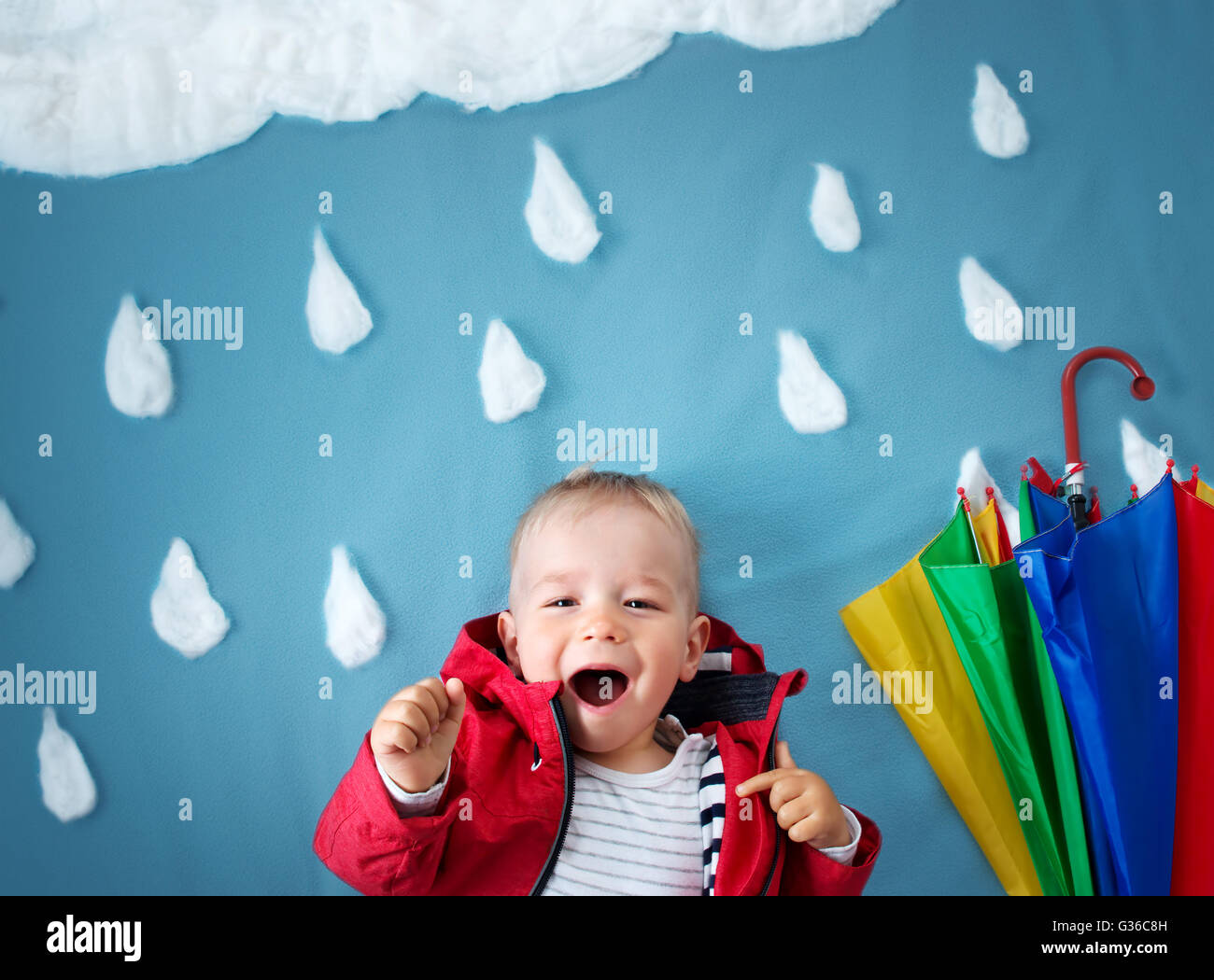 Little boy on blue background in coat with drop shapes Stock Photo - Alamy