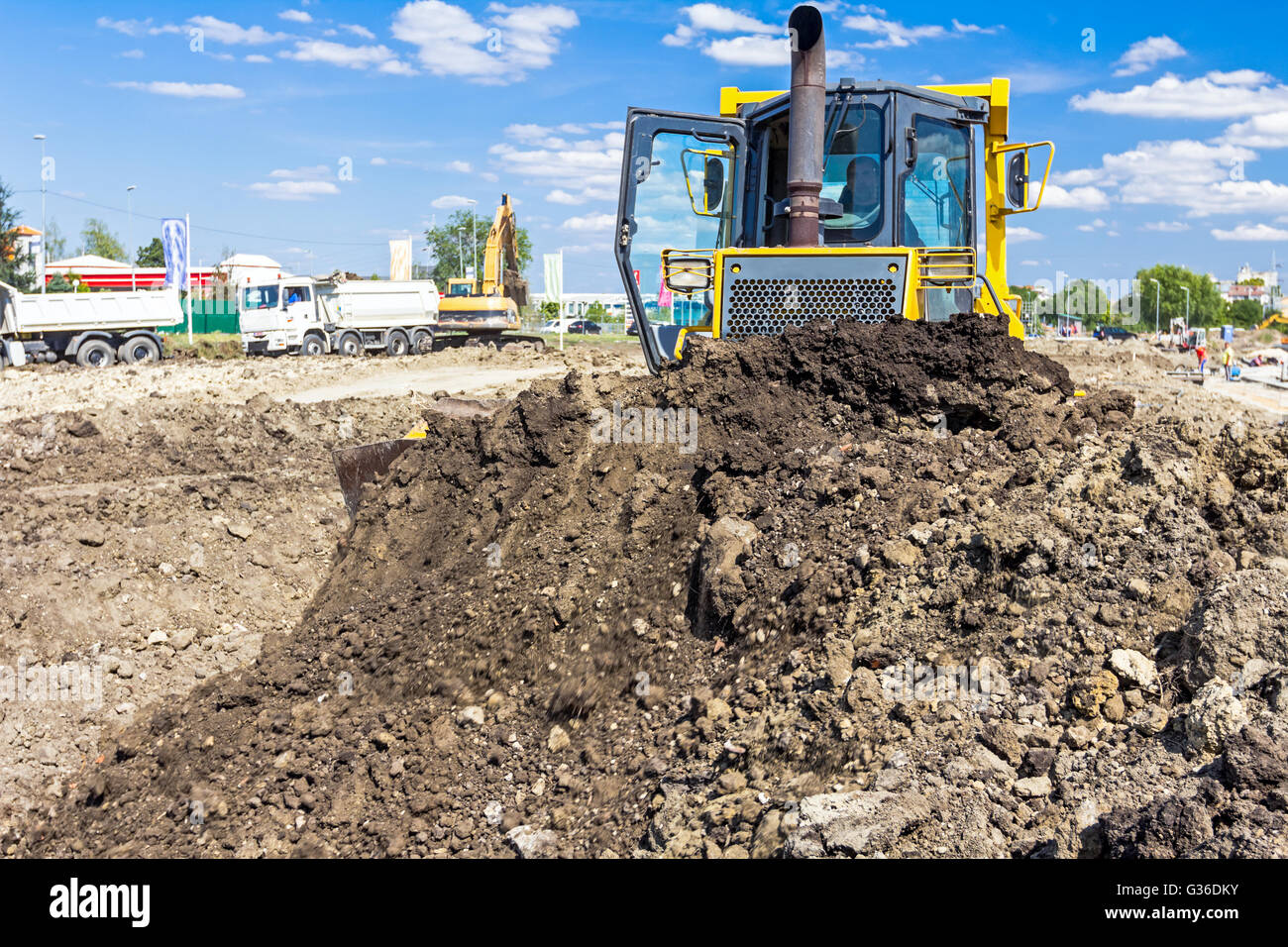 Earthmover with caterpillar is moving earth outdoors Stock Photo - Alamy