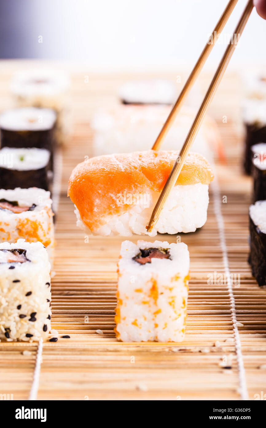 a salmon nigiri sushi being picked up with chopsticks with different ...