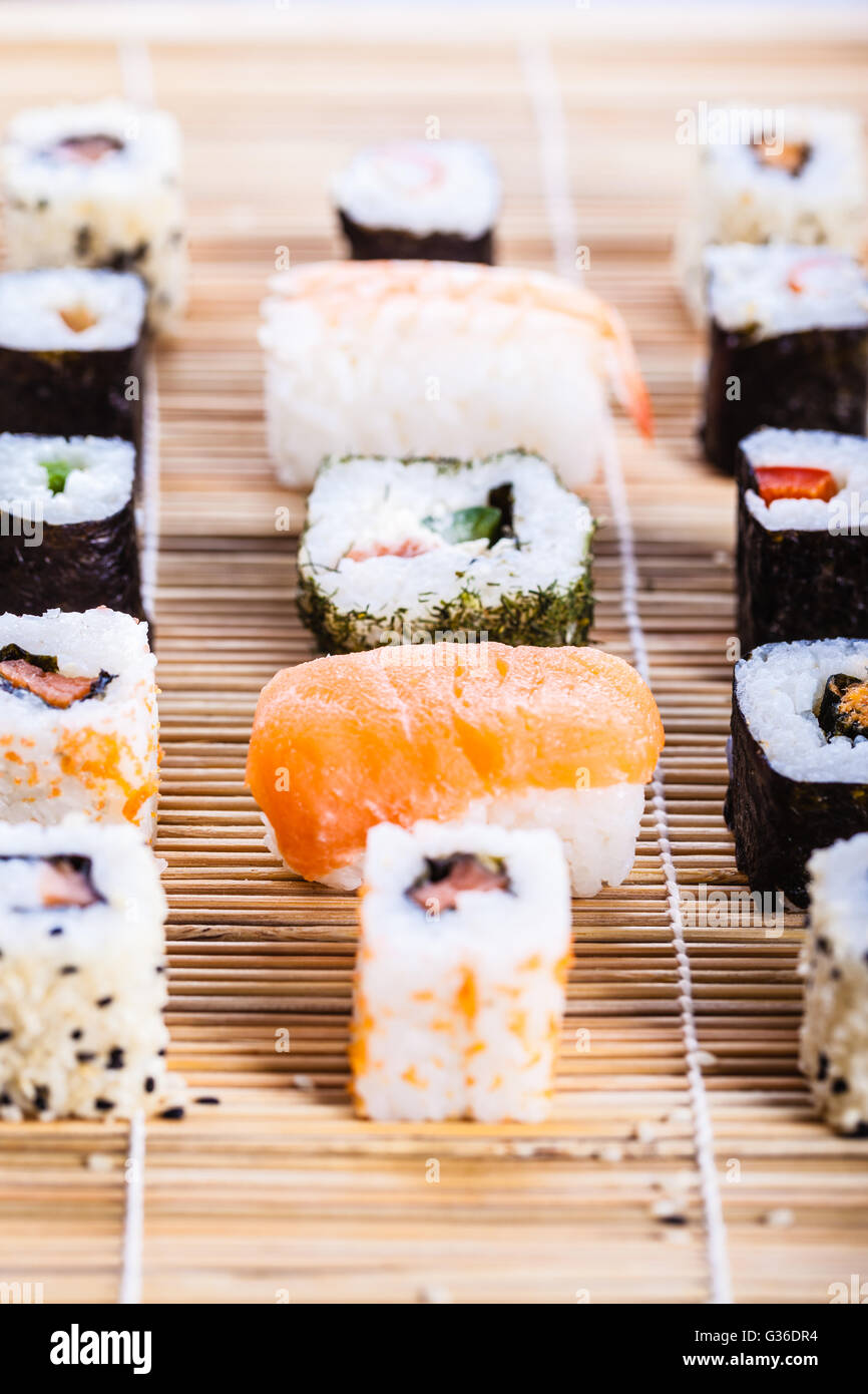 an assortment of different sushi pieces on a wooden bamboo sushi mat ...