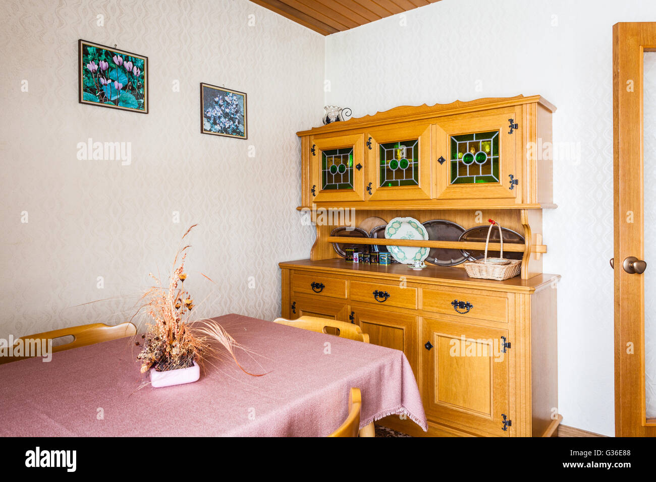 a dining room with a table and a plate rack Stock Photo - Alamy