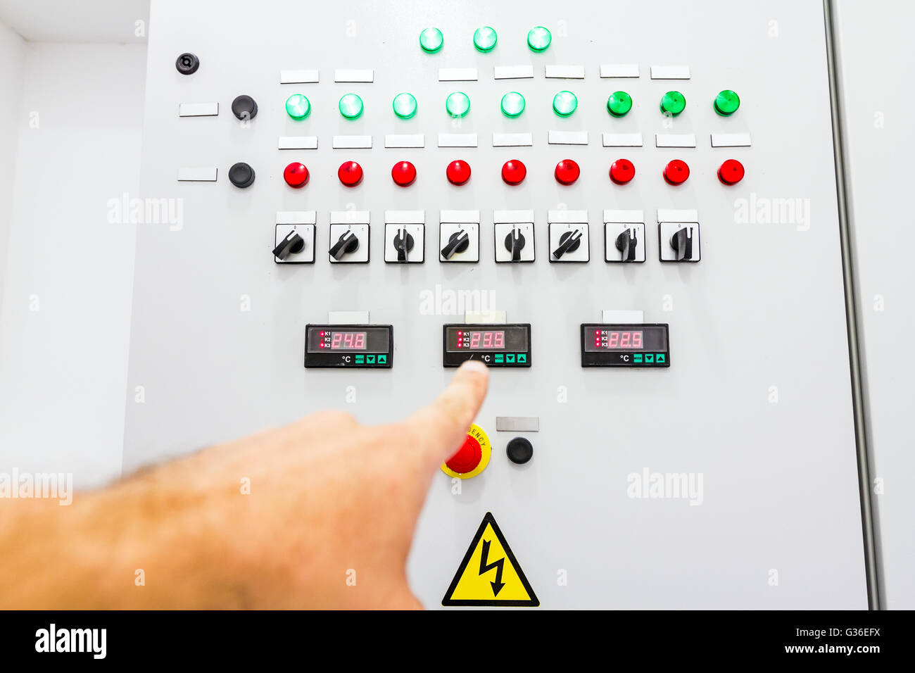 Hand is showing on electrical control panel which contains a digital ...
