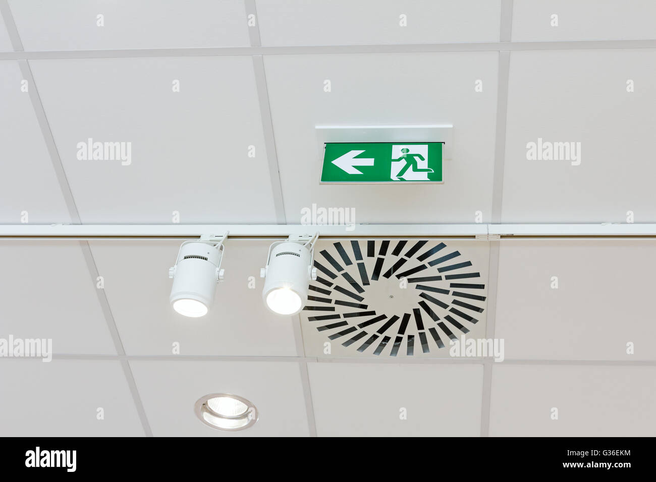 Standard international symbol safe exit sign is hanging from the ...