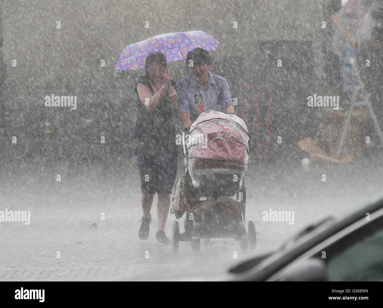 People are caught out in a heavy rain shower in Westminster, London ...