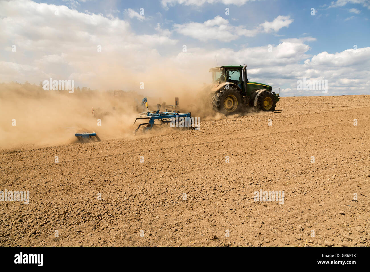 Tractor ploughing a field with a trail of dust behind it Stock Photo ...