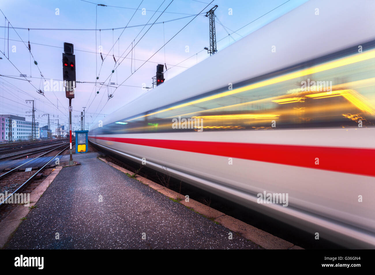 High speed passenger train on railroad track in motion at night ...