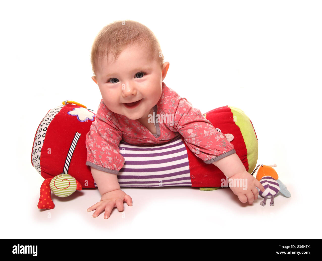 baby girl playing on a tummy time roll cutout Stock Photo - Alamy