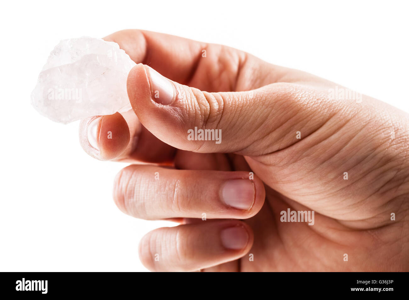 a male hand holding a fragment of rock crystal mineral isolated on a ...