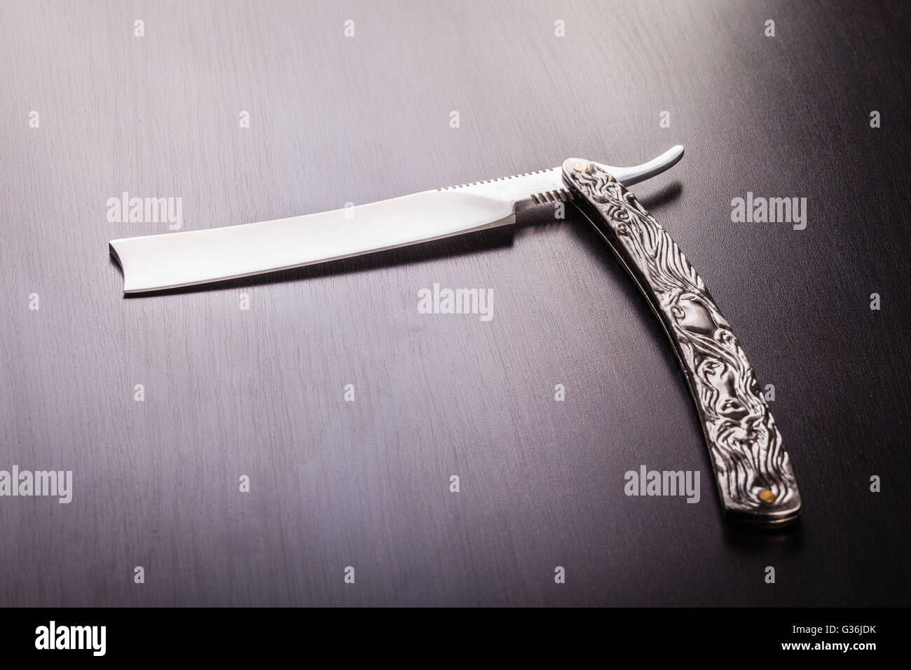 a big cut throat straight razor over a dark wooden backgroun Stock ...