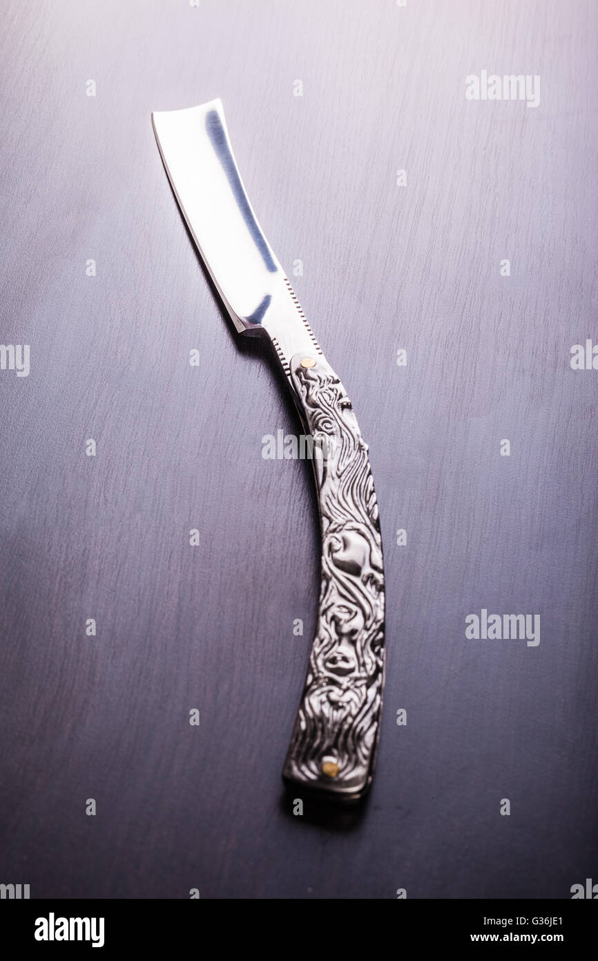 a big cut throat straight razor over a dark wooden backgroun Stock ...