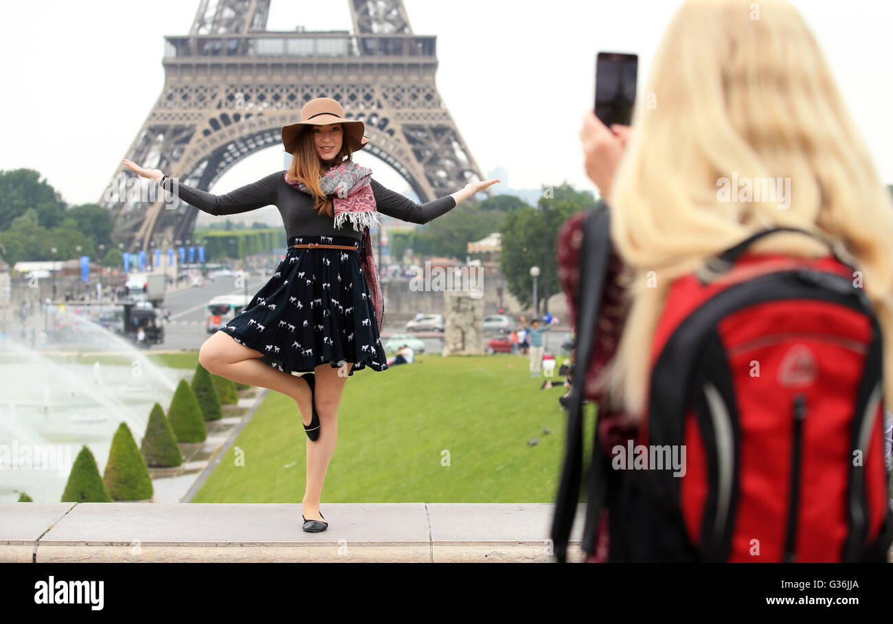 A woman poses for a photo near the Eiffel Tower, Paris. PRESS ...