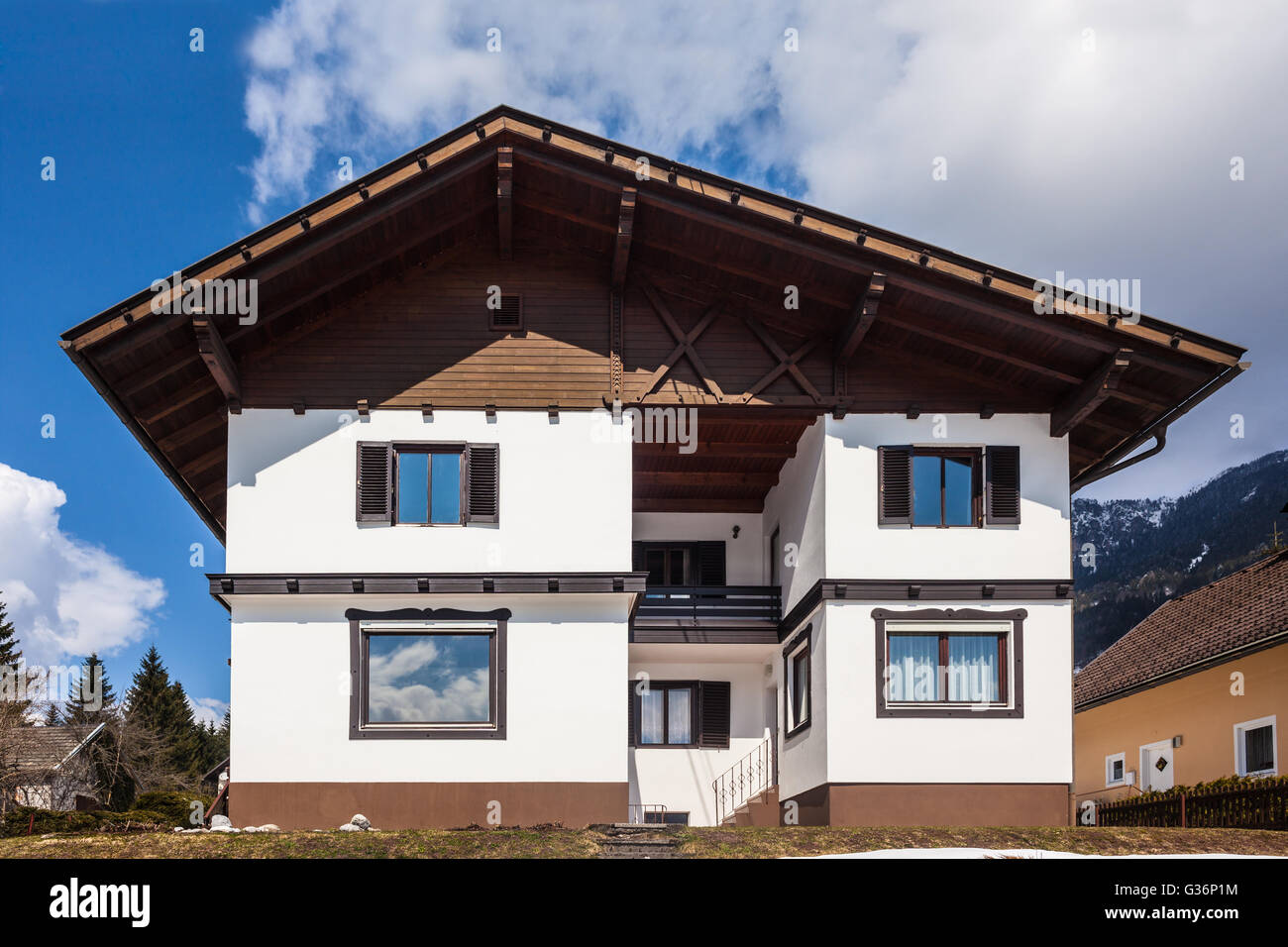 a traditional big austrian house in winter with a vibrant blue sky ...