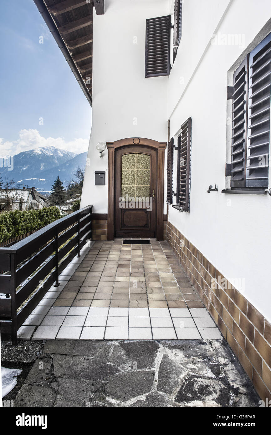 a traditional big austrian house in winter with a vibrant blue sky ...