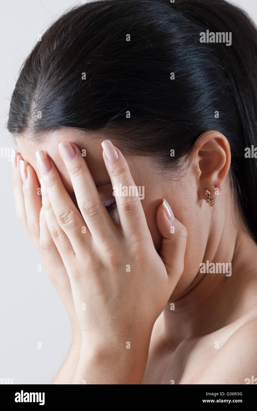 Young woman hiding face with hands Stock Photo - Alamy