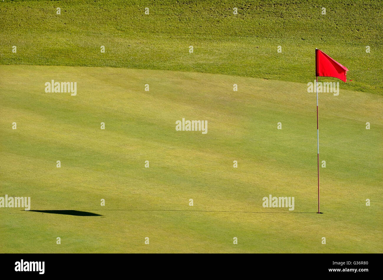 Golf course with red flag in the hole Stock Photo - Alamy