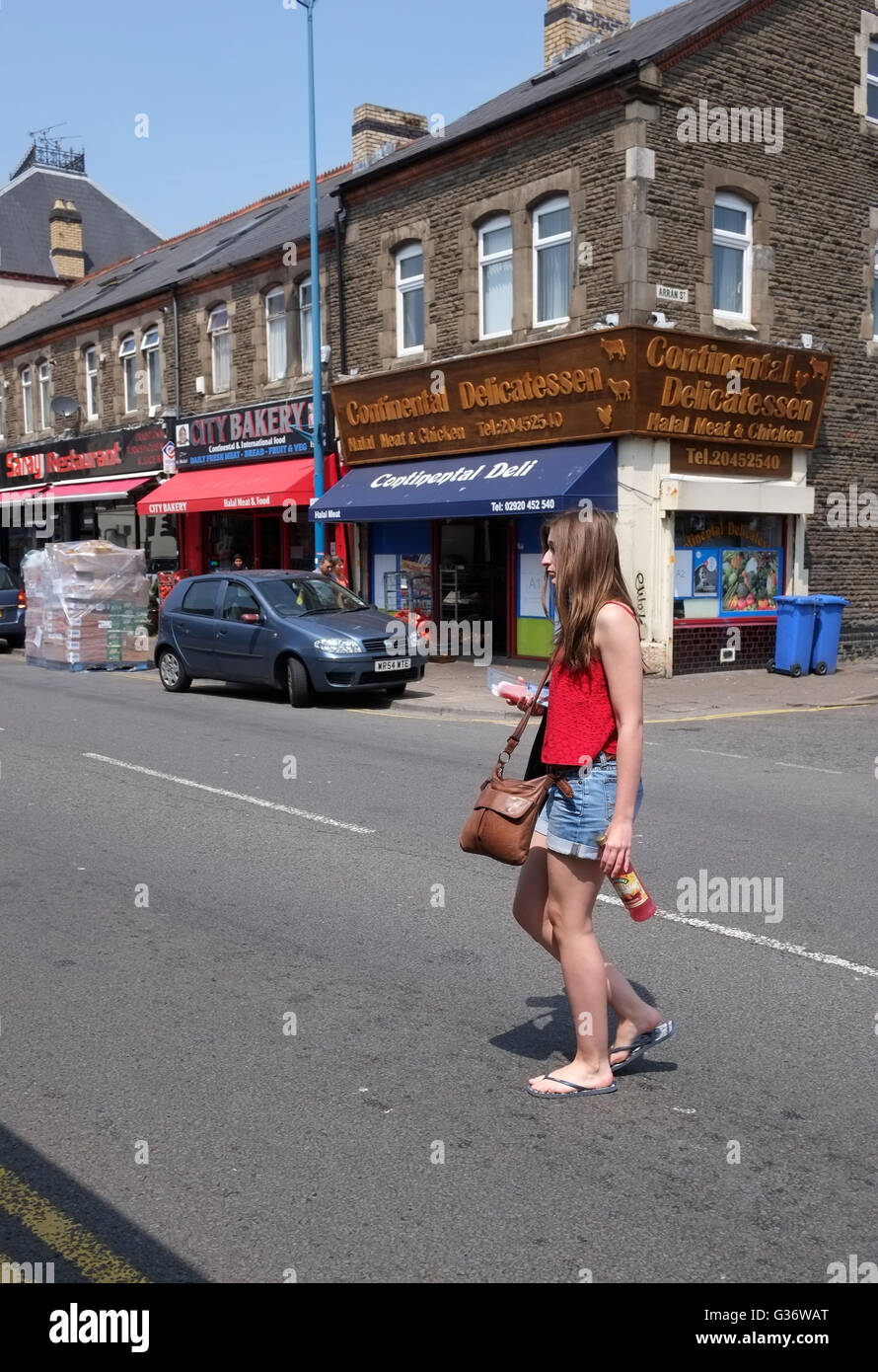 Girl crossing the road in front of shops and business's on City Road ...