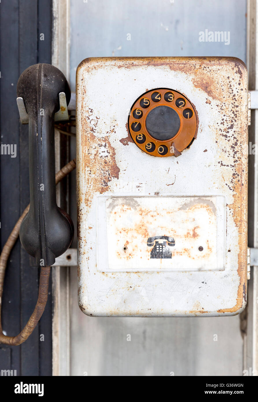 Rusty old vintage rotary pay phone for public use. Old pay telephone ...