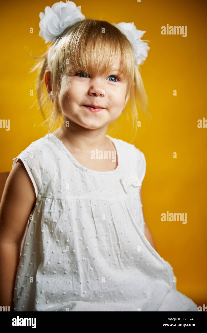 little girl with bows and fooling around in a white dress Stock Photo ...