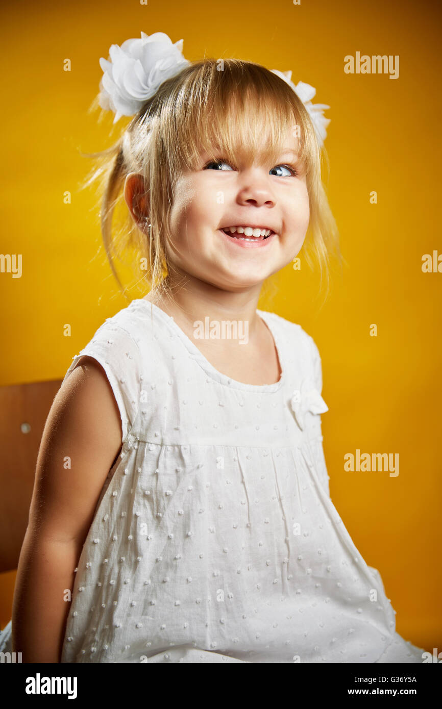 little girl with bows and fooling around in a white dress Stock Photo ...