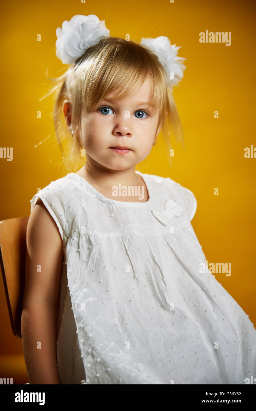 little girl with bows and fooling around in a white dress Stock Photo ...
