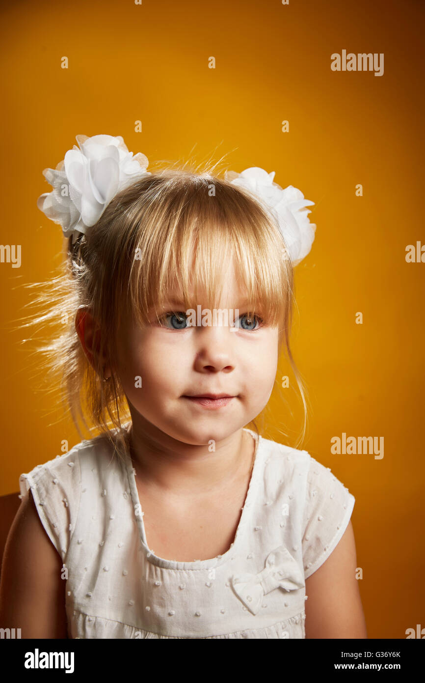 little girl with bows and fooling around in a white dress Stock Photo ...