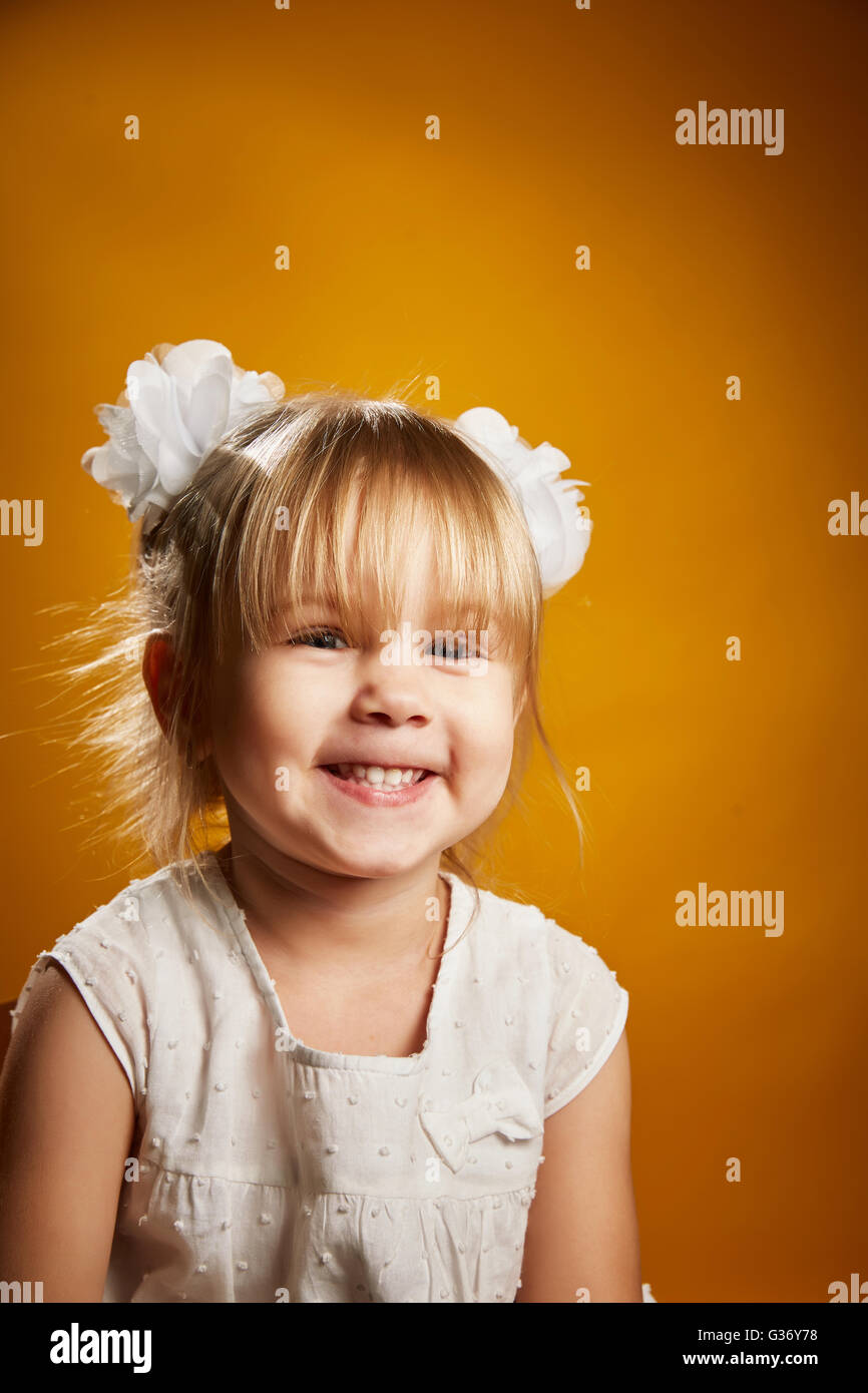 little girl with bows and fooling around in a white dress Stock Photo ...