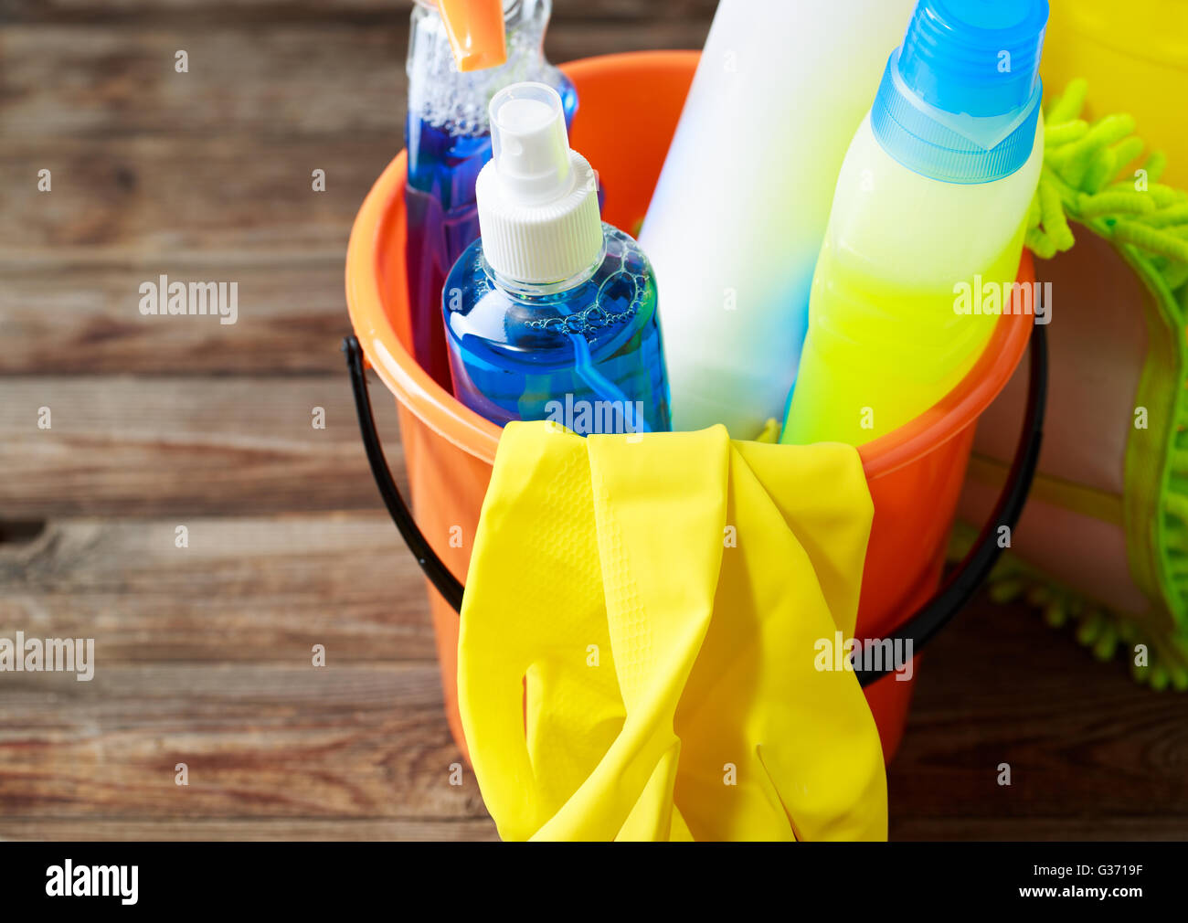 Plastic bucket with cleaning supplies on wood background Stock Photo ...