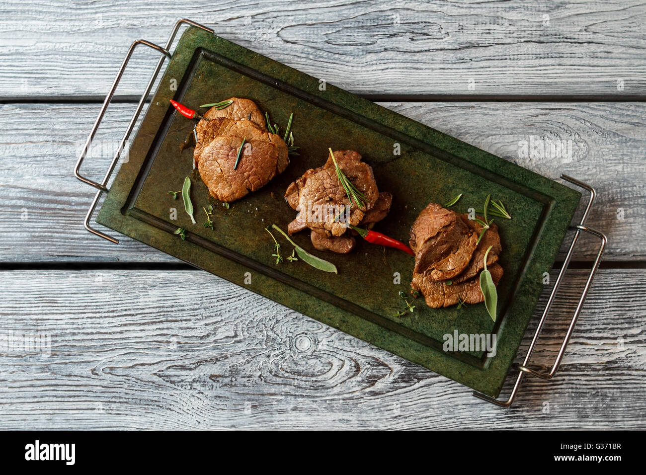 Green tray with cooked meat Stock Photo - Alamy