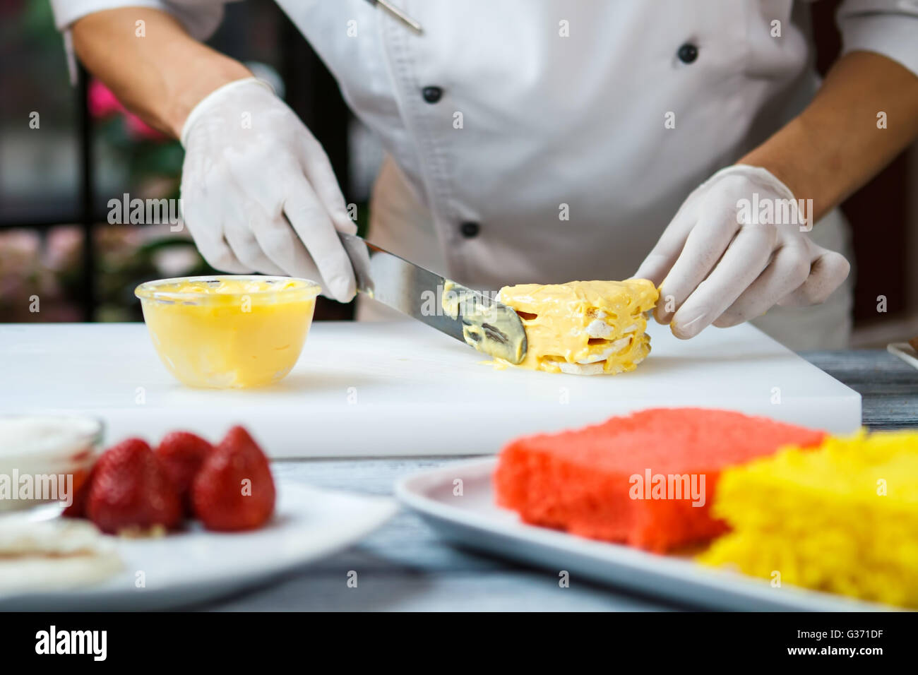 Hand with spatula touches shortcake Stock Photo - Alamy