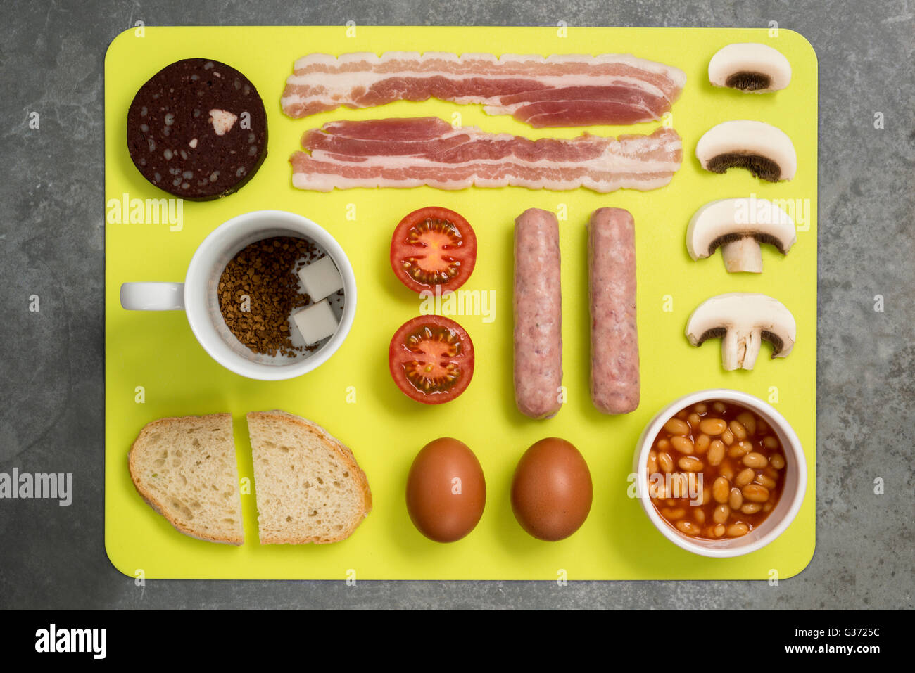 Overhead shot of selection of cooked English breakfast on a yellow ...