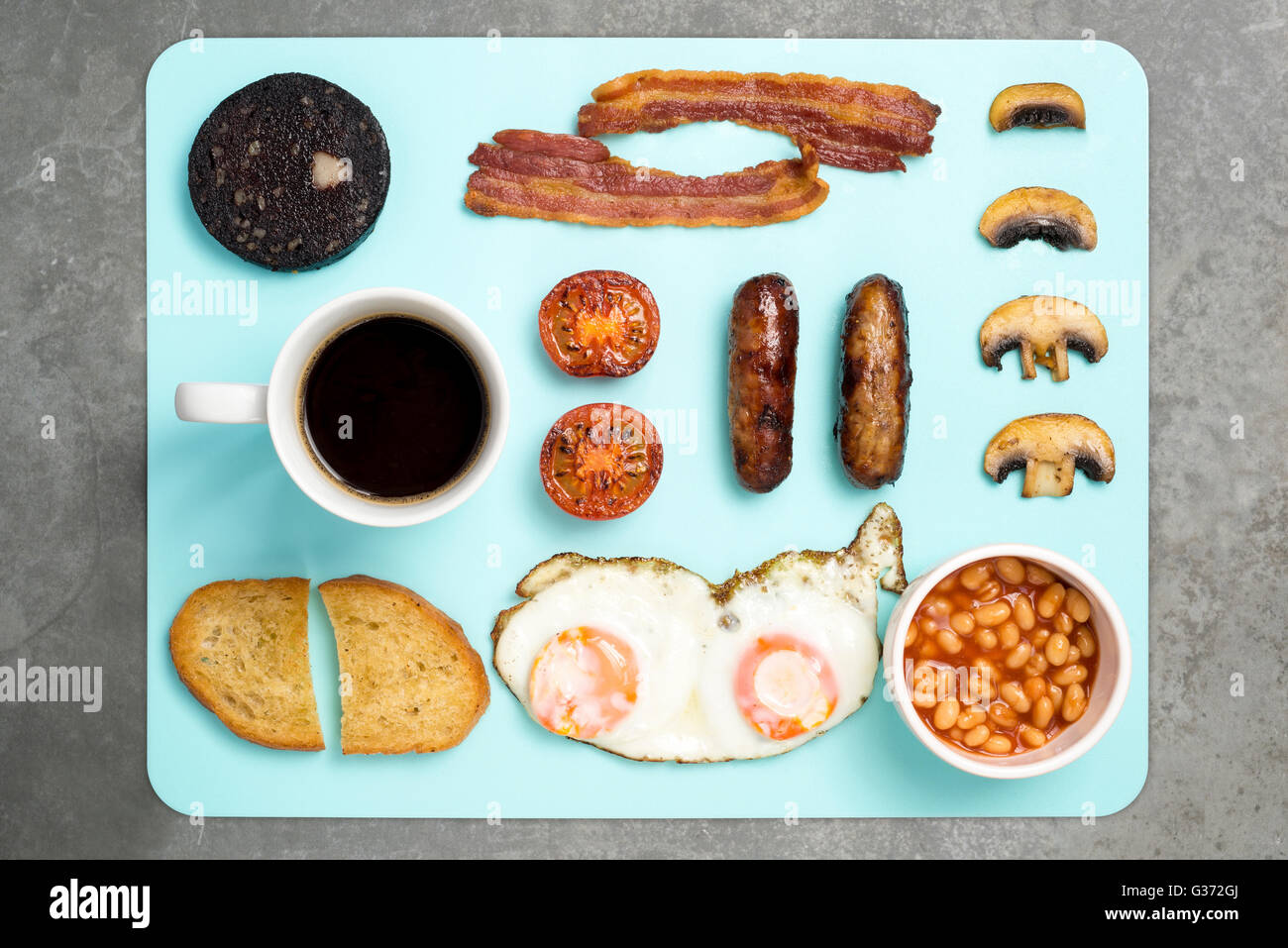 Overhead shot of selection of cooked English breakfast on a blue dining ...
