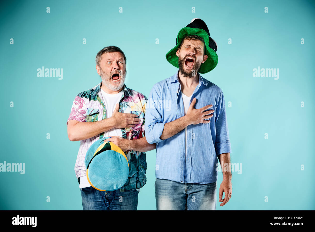 The two football fans singing the national anthem over blue Stock Photo ...