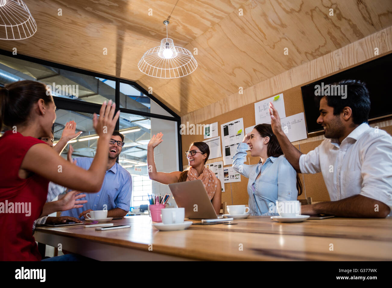 Casual colleagues doing high-five Stock Photo - Alamy
