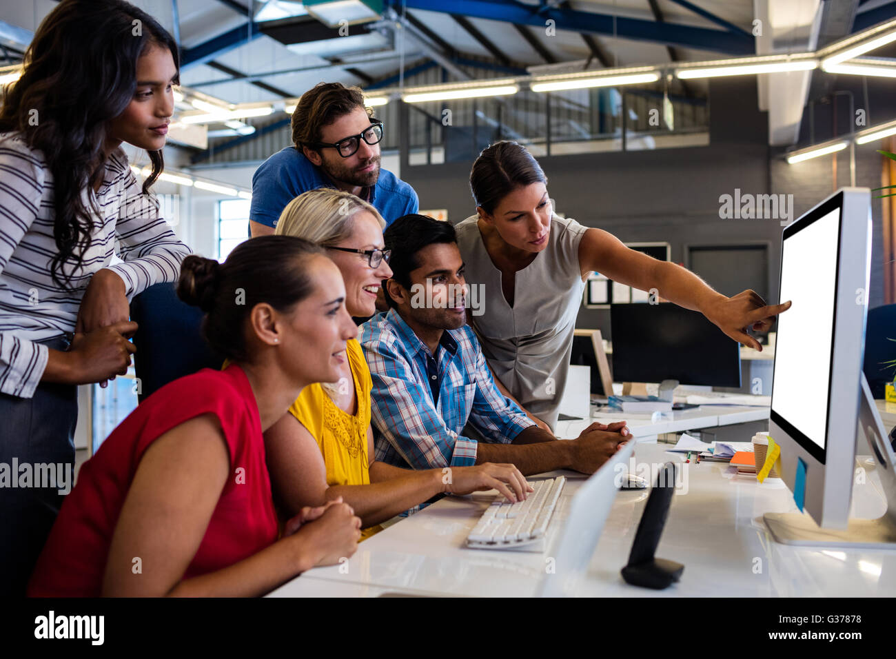 Casual business team working on one computer Stock Photo - Alamy