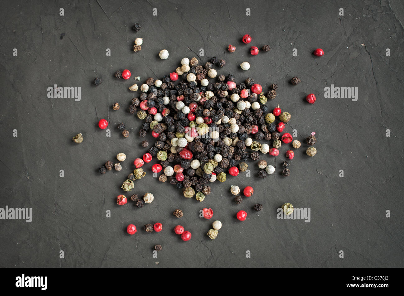 Colored pepper mix on a dark background Stock Photo - Alamy