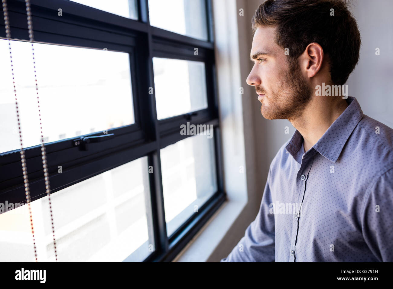 Businessman looking out of the window Stock Photo - Alamy