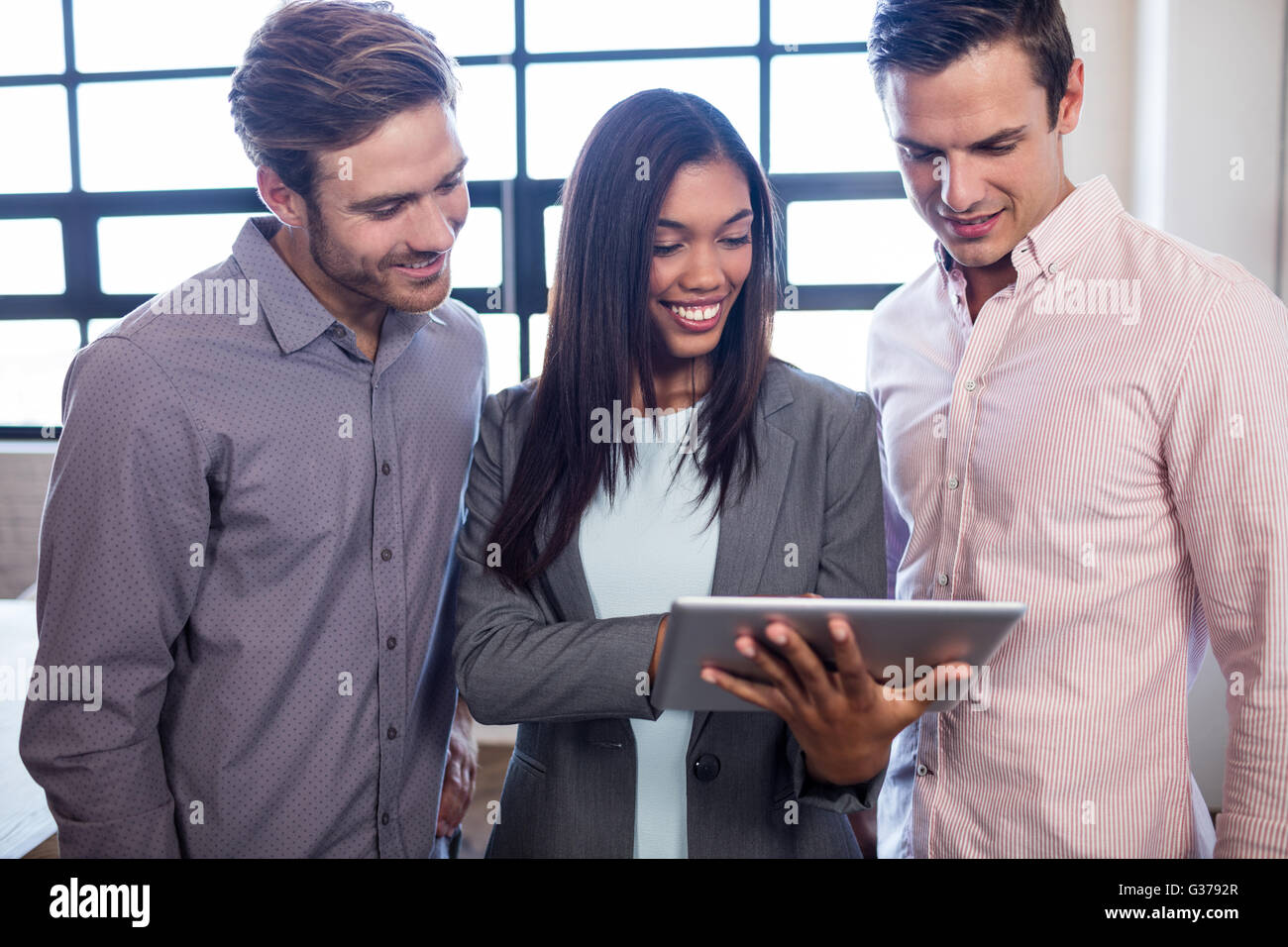 Colleagues using a tablet Stock Photo - Alamy
