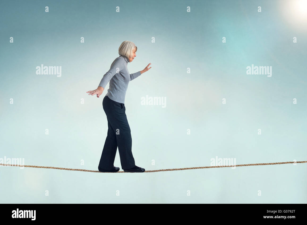 senior woman walking on a tightrope Stock Photo - Alamy