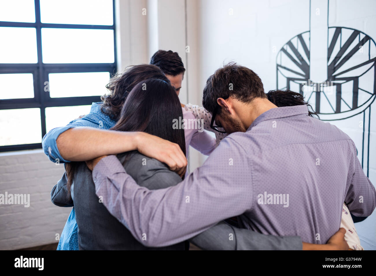 Group of coworkers arms in arms Stock Photo - Alamy