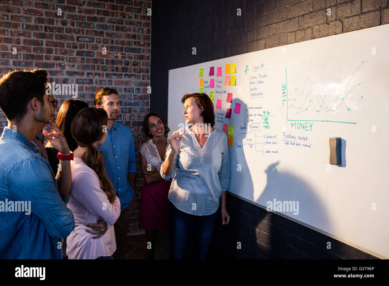Coworkers front of a board Stock Photo - Alamy