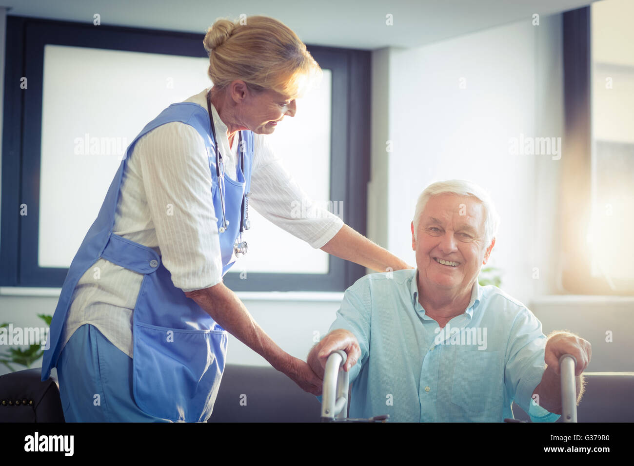 Female doctor helping senior man to walk with walker Stock Photo - Alamy