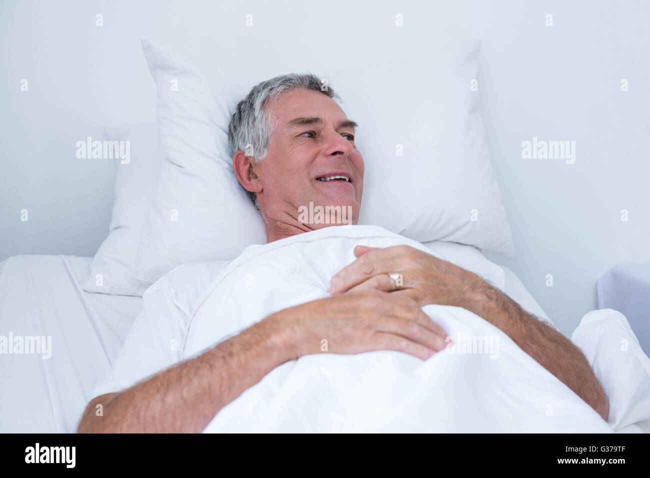 Senior man lying on bed Stock Photo - Alamy