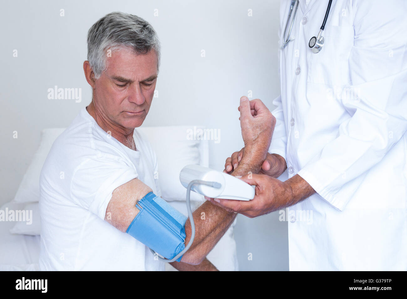 Doctor checking senior mans blood pressure Stock Photo - Alamy