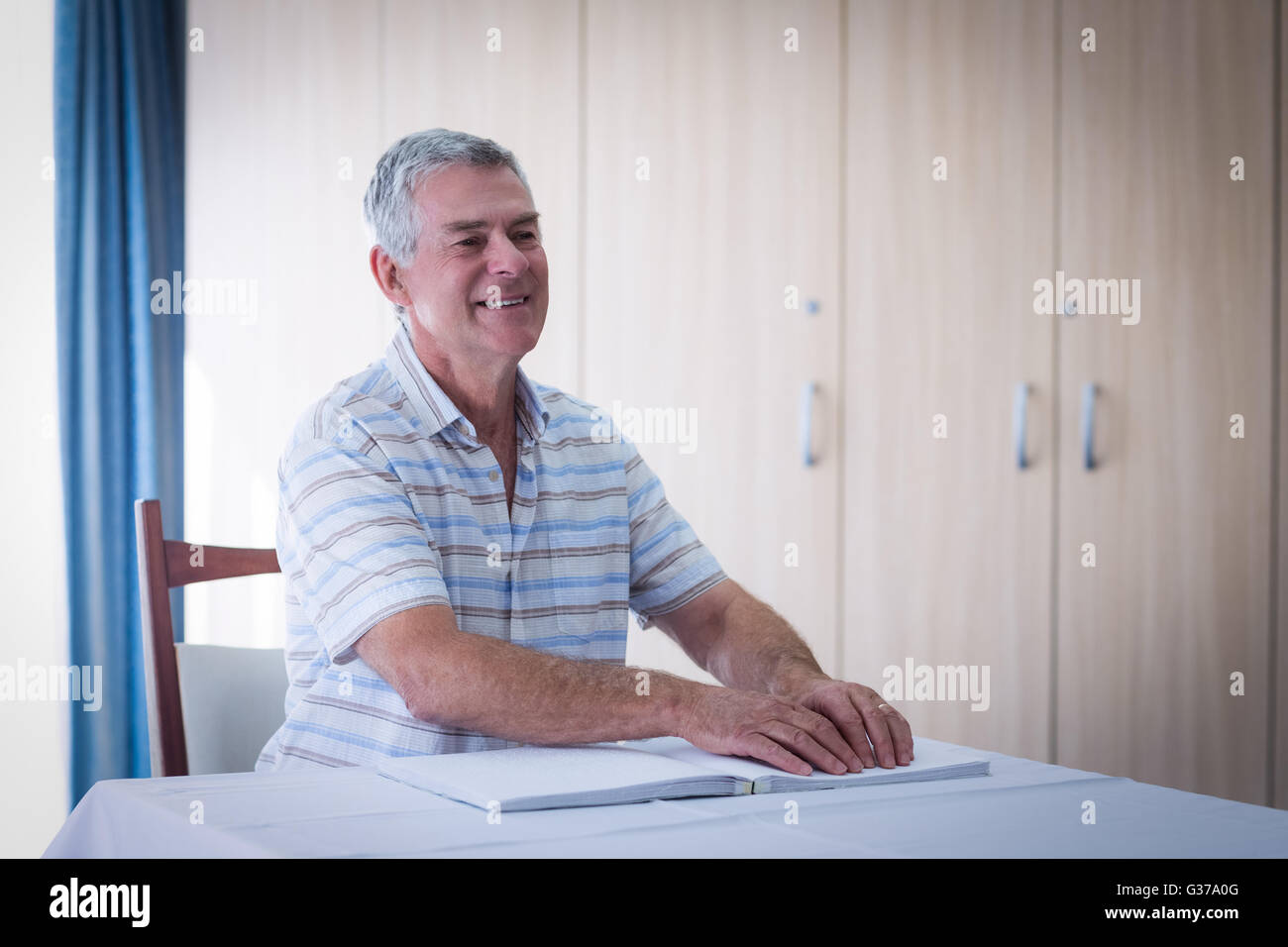 Blind man reading a braille book Stock Photo - Alamy