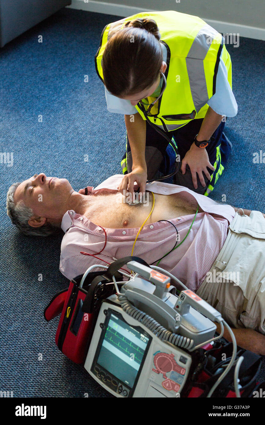 Paramedic examining a patient during cardiopulmonary resuscitation ...