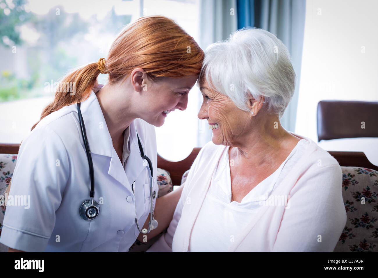 Smiling doctor and patient looking face to face Stock Photo - Alamy